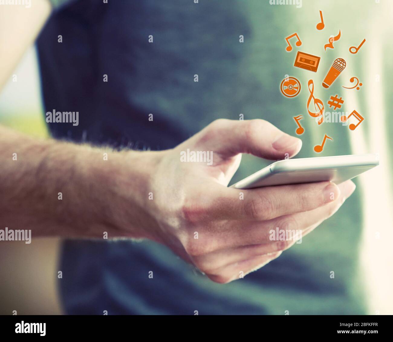 Hand holding smartphone with music icons Stock Photo - Alamy