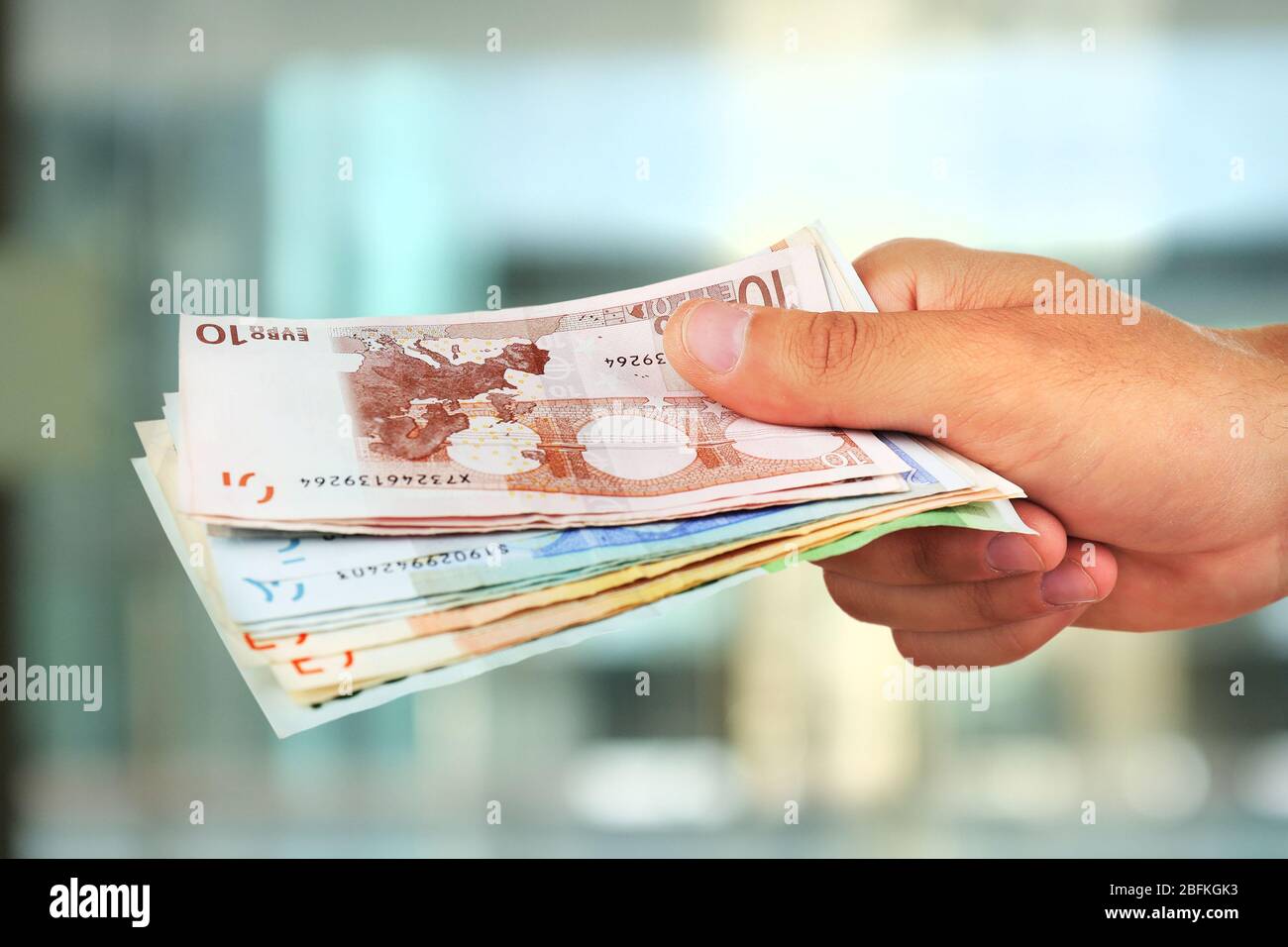 Hand with euro Stock Photo - Alamy