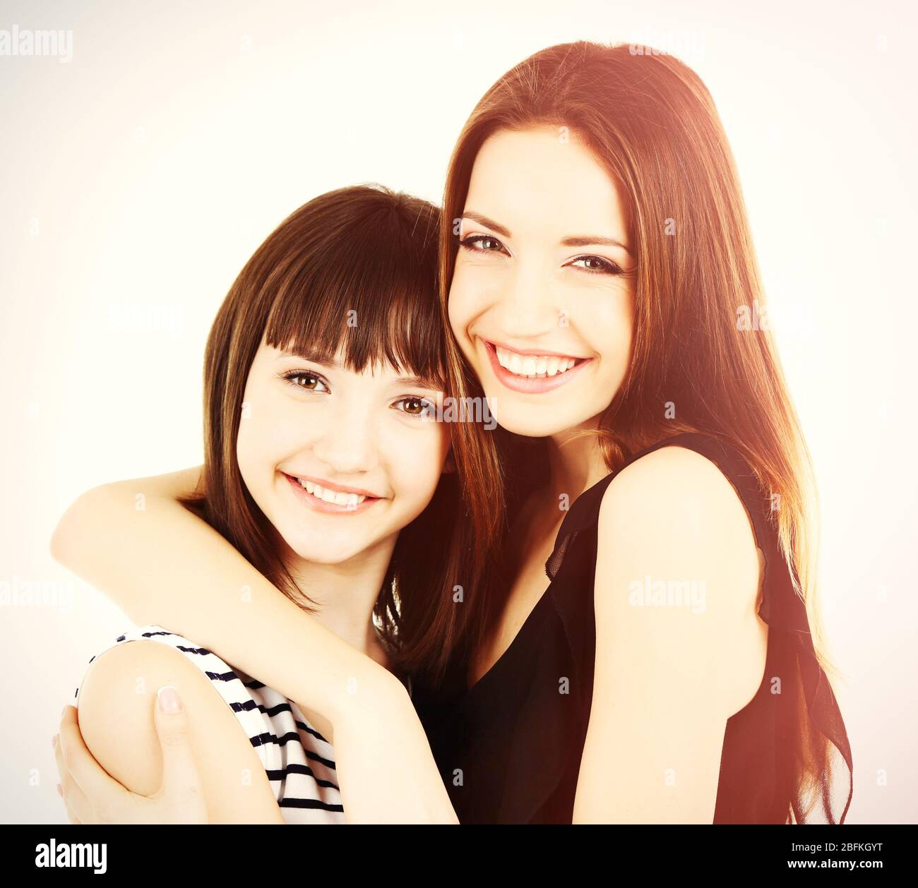 Two beautiful girls on light background Stock Photo - Alamy