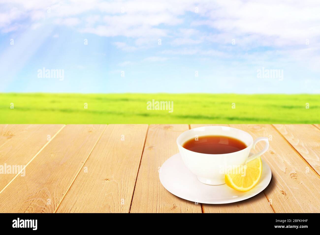 Cup of tea on wooden table, on nature background Stock Photo - Alamy