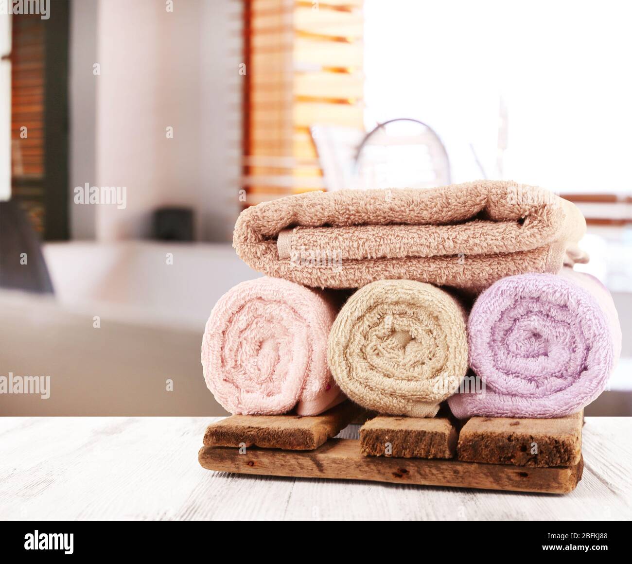 Rolled bath towels on wooden table in bathroom Stock Photo - Alamy