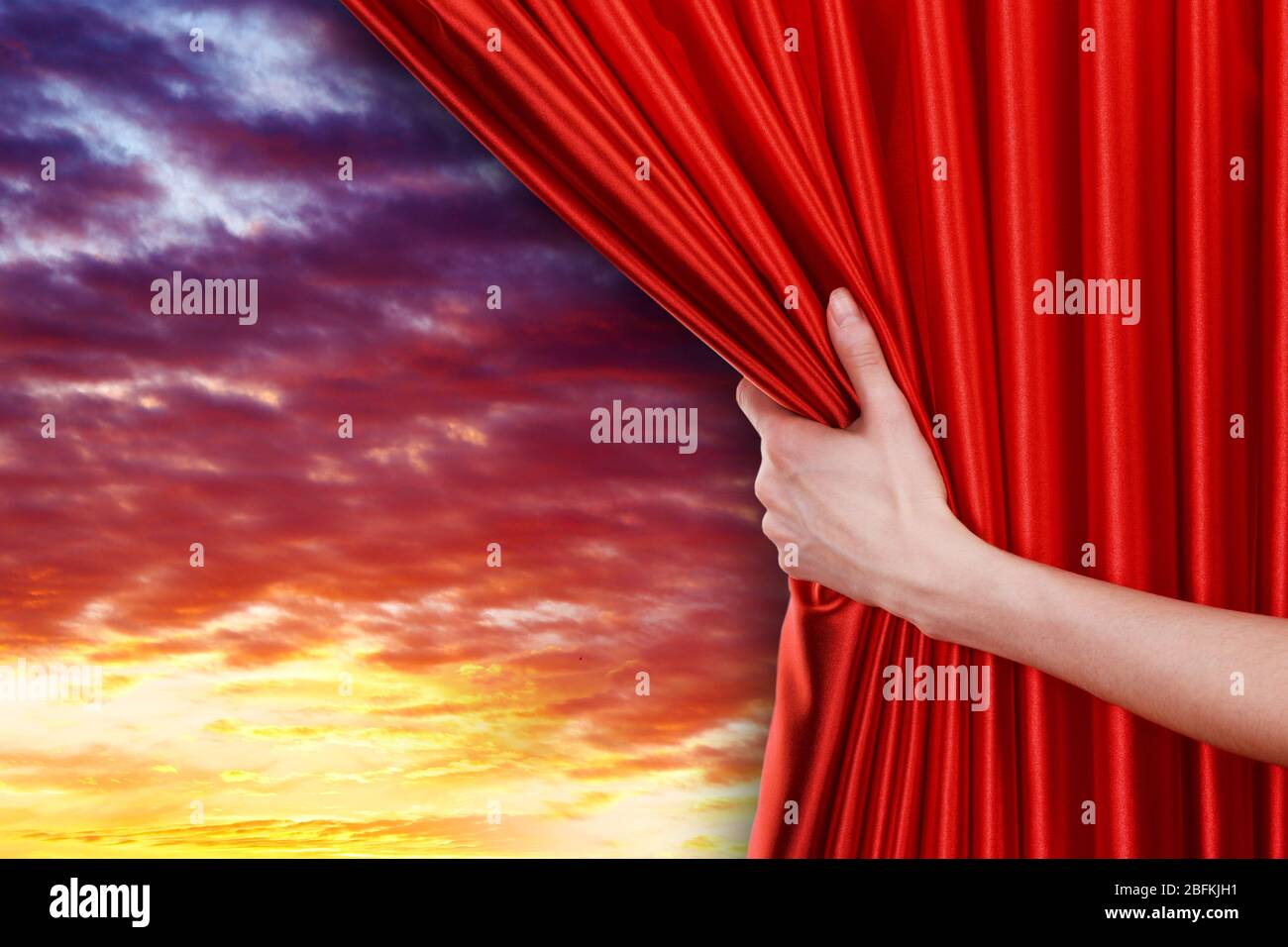 Human hand opens red curtain on sky background Stock Photo - Alamy