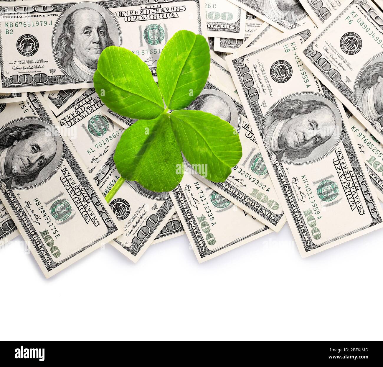 Clover leaf and dollars on white surface Stock Photo - Alamy