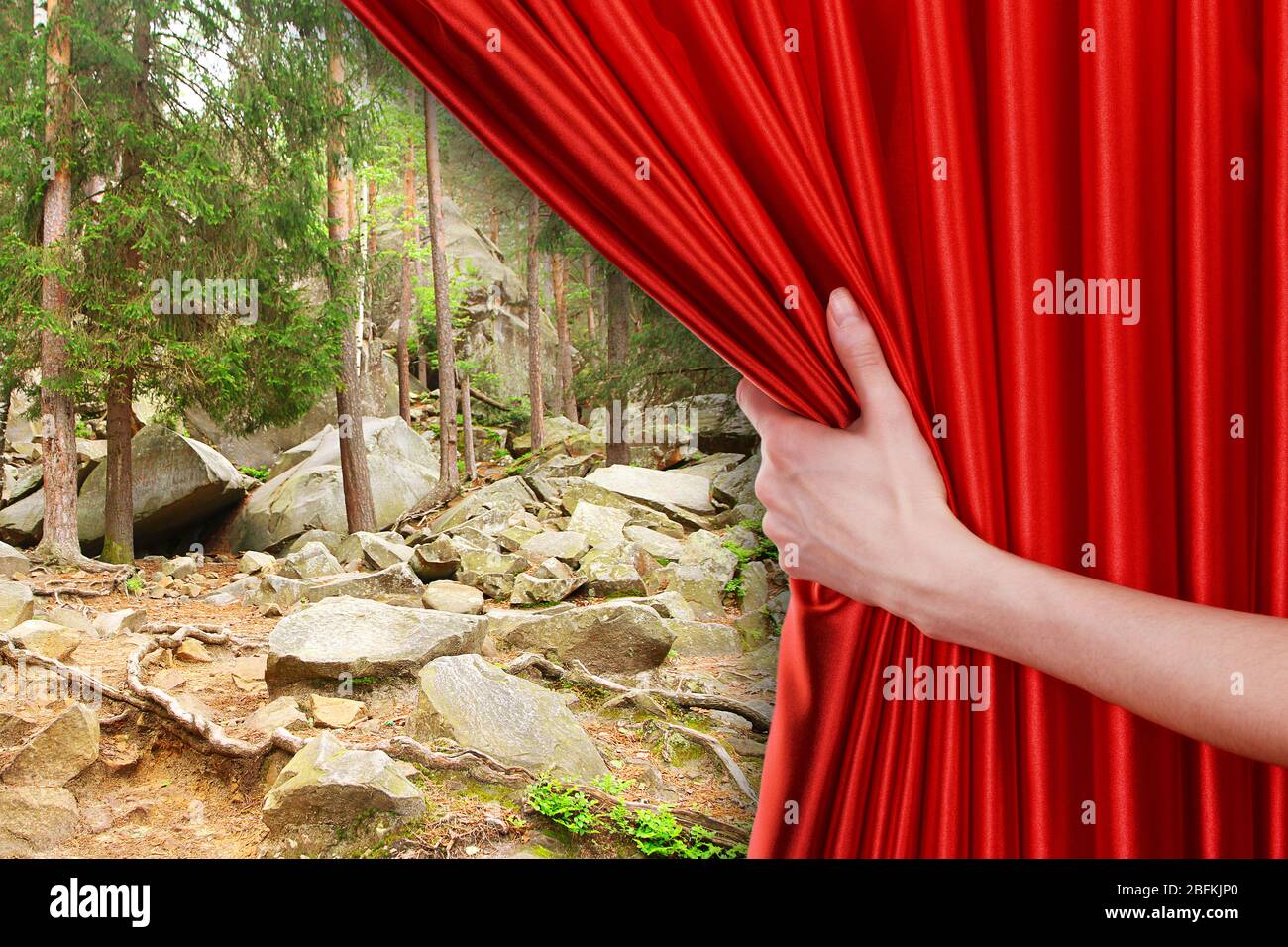 Human hand opens red curtain on nature background Stock Photo - Alamy