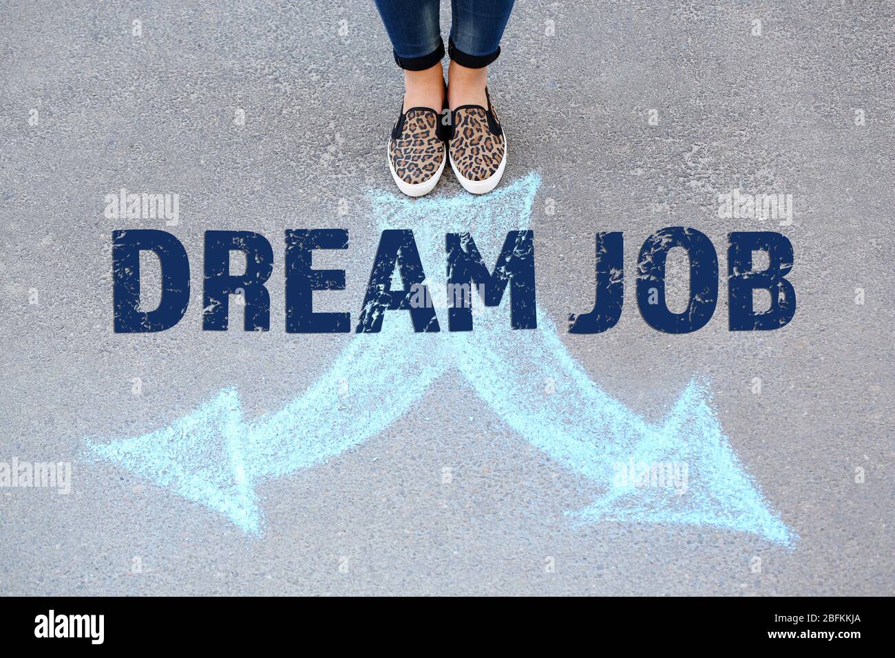Dream job concept. Female feet and drawing arrow on pavement background ...