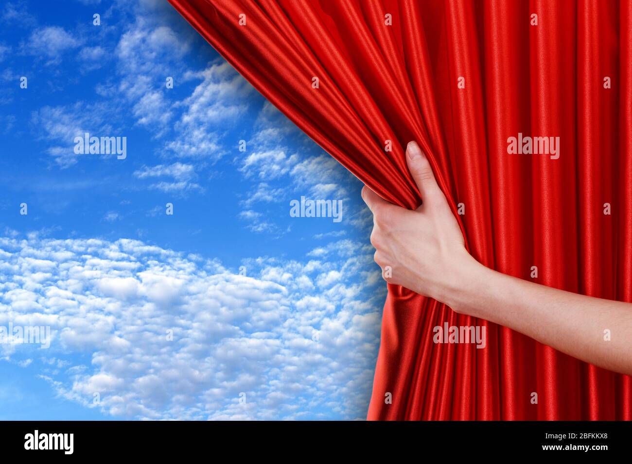 Human hand opens red curtain on sky background Stock Photo - Alamy