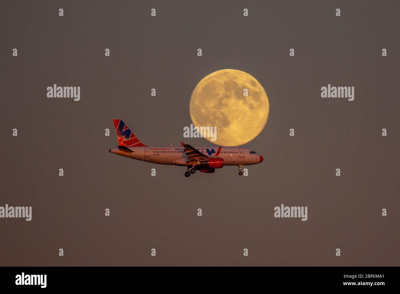 Airplane flying in front of the moon Stock Photo - Alamy