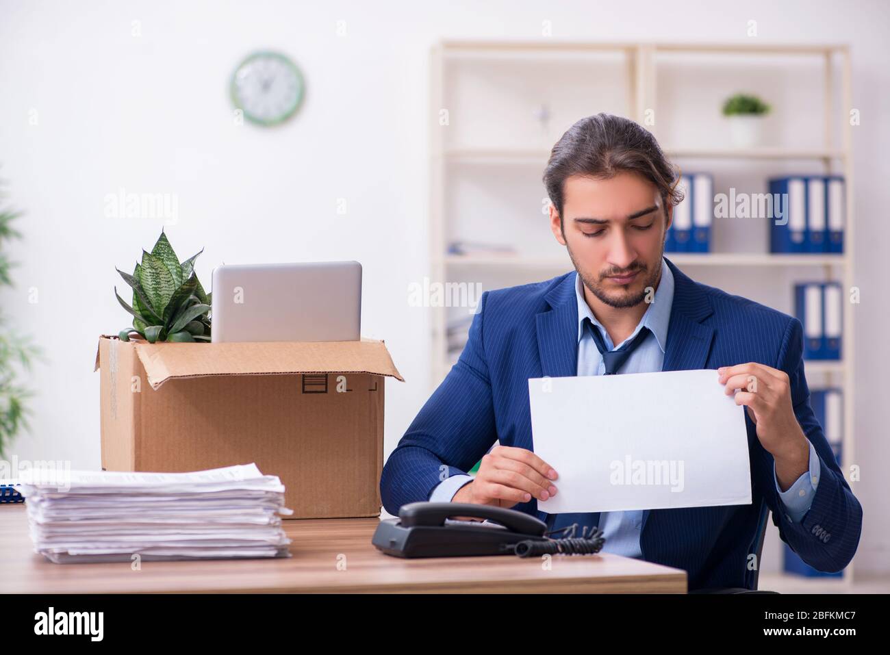 Young man being fired from his workplace Stock Photo - Alamy