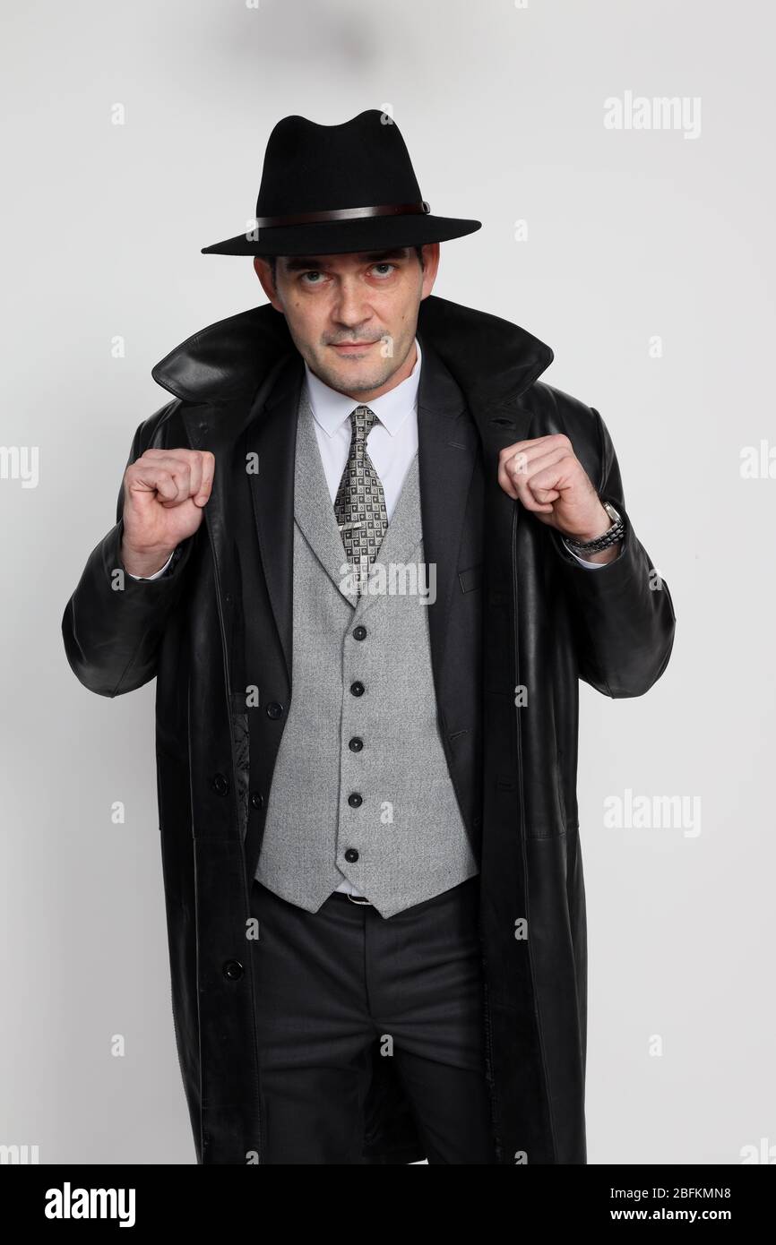 Handsome middle aged gangster man posing in studio on isolated ...