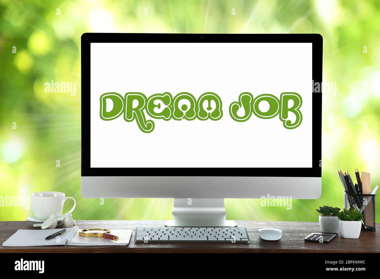 Dream job concept. Computer on nature green background Stock Photo - Alamy
