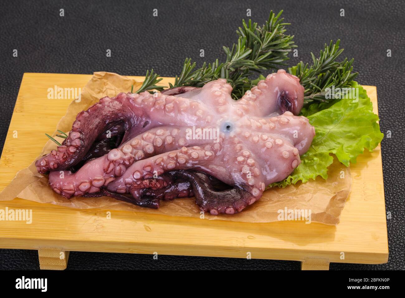 Raw octopus ready for cooking with rosemary Stock Photo - Alamy