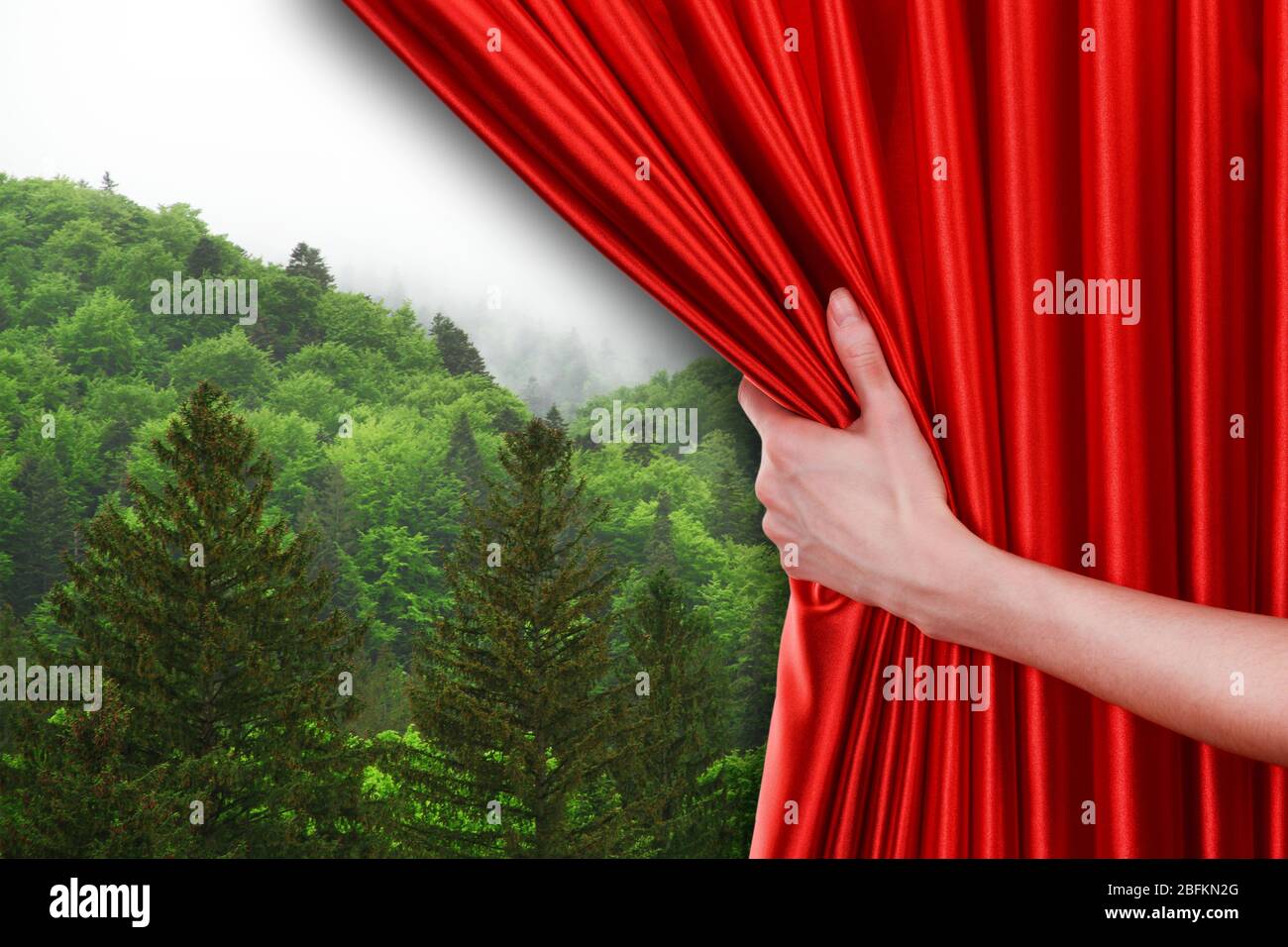 Human hand opens red curtain on nature background Stock Photo - Alamy