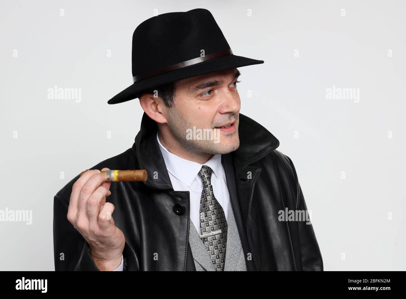 Handsome middle aged gangster man posing in studio on isolated ...