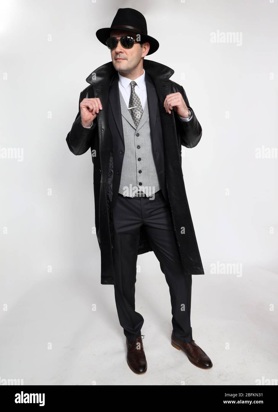 Handsome middle aged gangster man posing in studio on isolated ...
