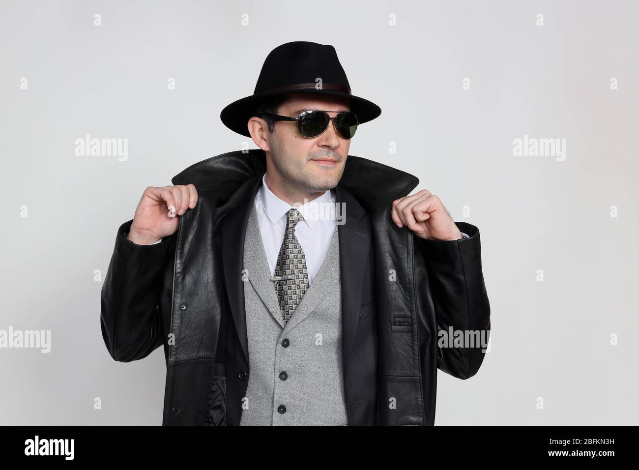 Handsome middle aged gangster man posing in studio on isolated ...