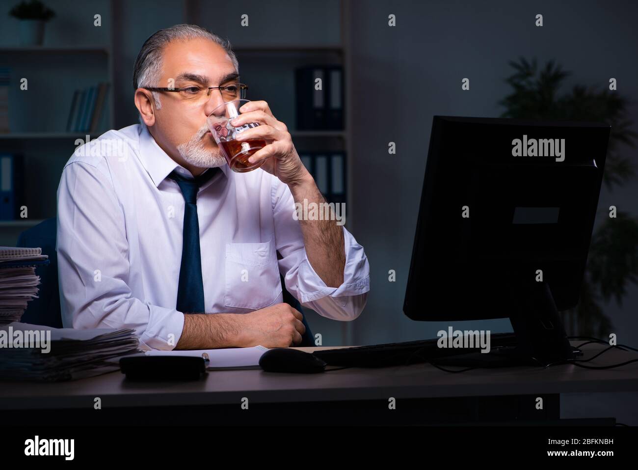 Old employee working late in the office Stock Photo - Alamy