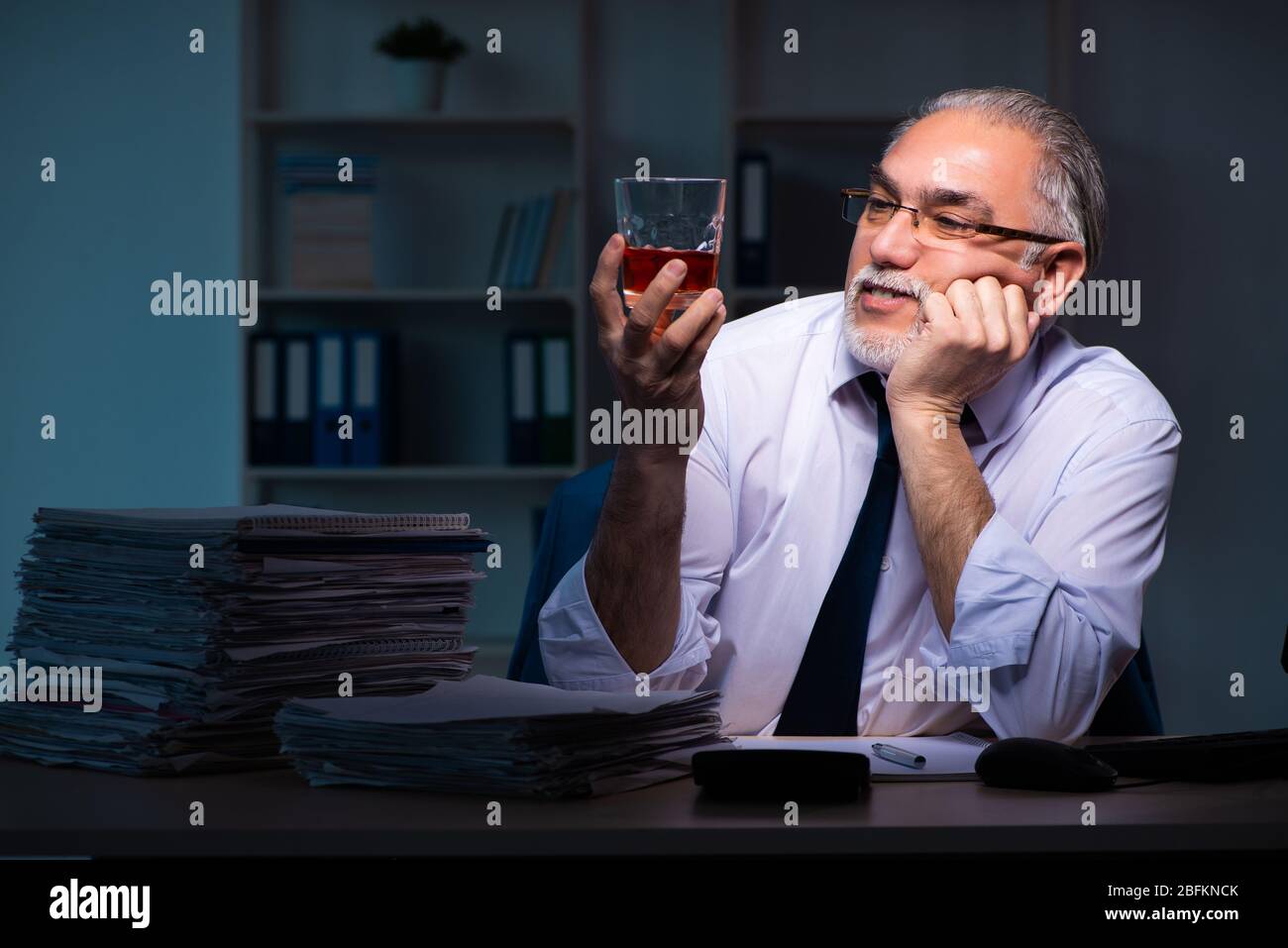 Old employee working late in the office Stock Photo - Alamy
