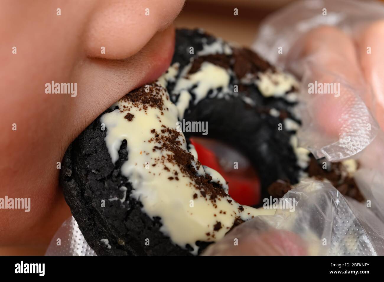 kid eating a fresh chocolate flavor donut Stock Photo - Alamy