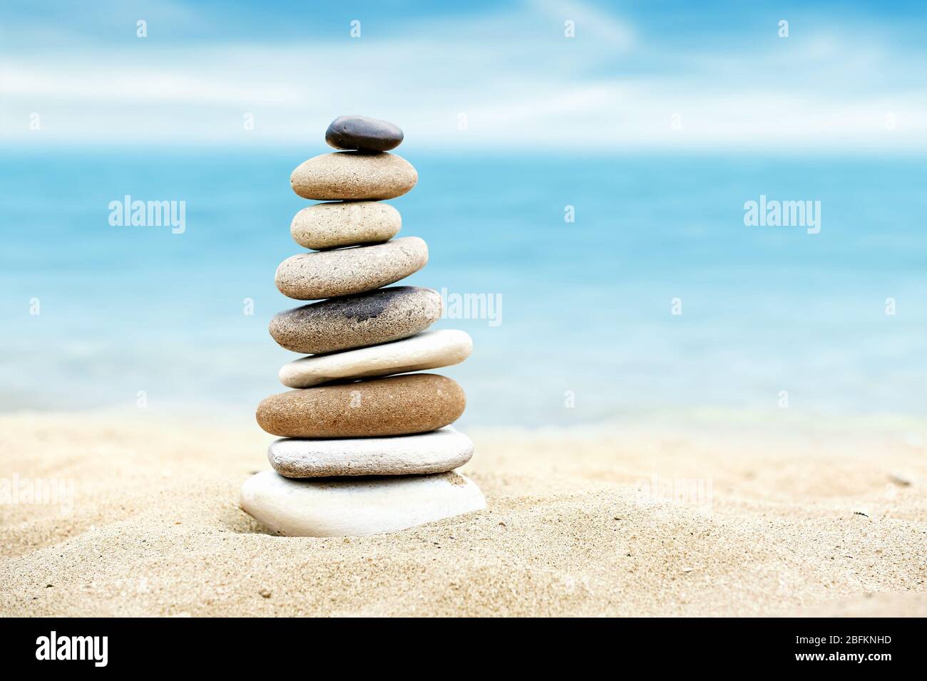 Tower of stones on sea beach background Stock Photo - Alamy