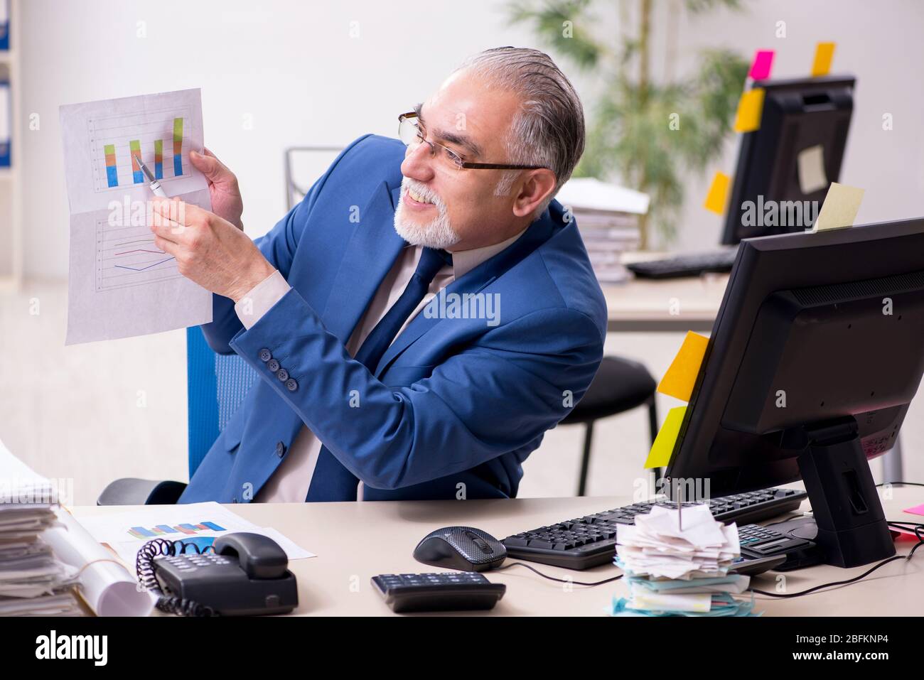 Old sales analyst working in the office Stock Photo - Alamy