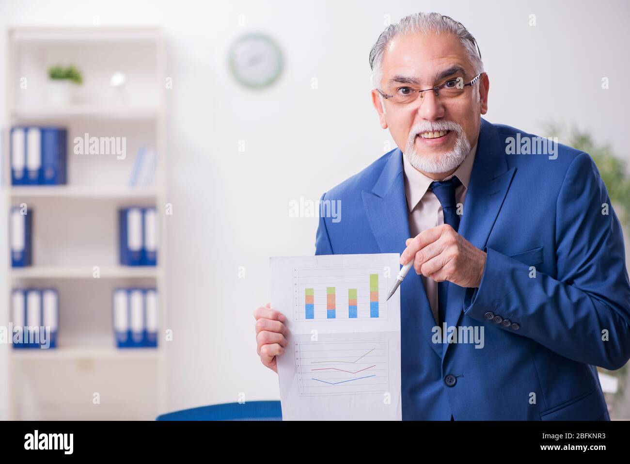 Old sales analyst working in the office Stock Photo - Alamy