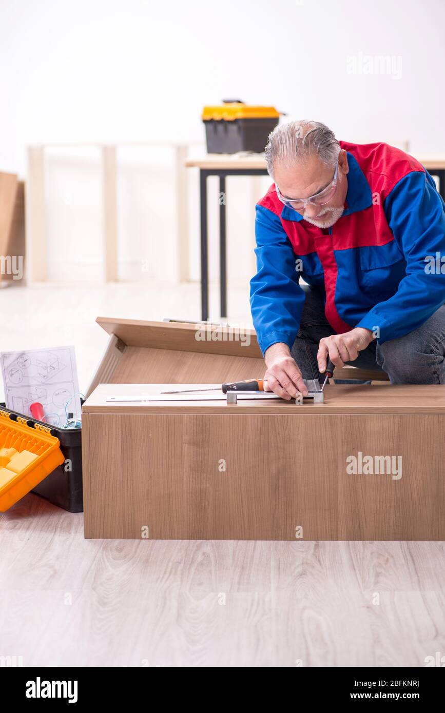 Old carpenter working indoors on furniture Stock Photo - Alamy