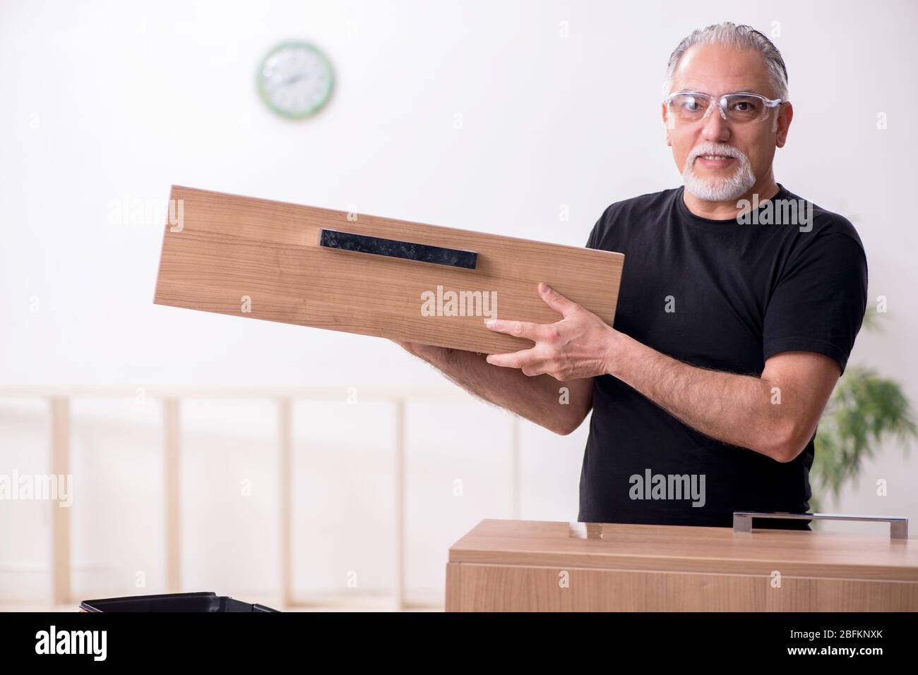 Old carpenter working indoors on furniture Stock Photo - Alamy