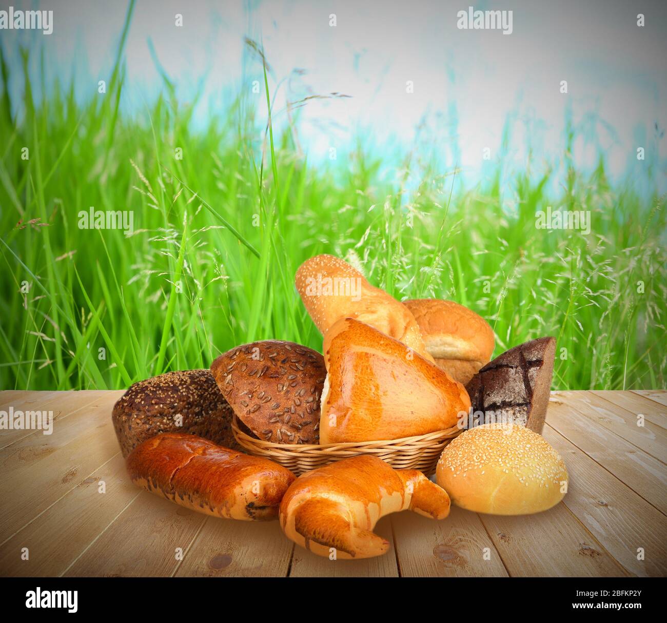 Fresh bread on wooden table, on nature background Stock Photo - Alamy