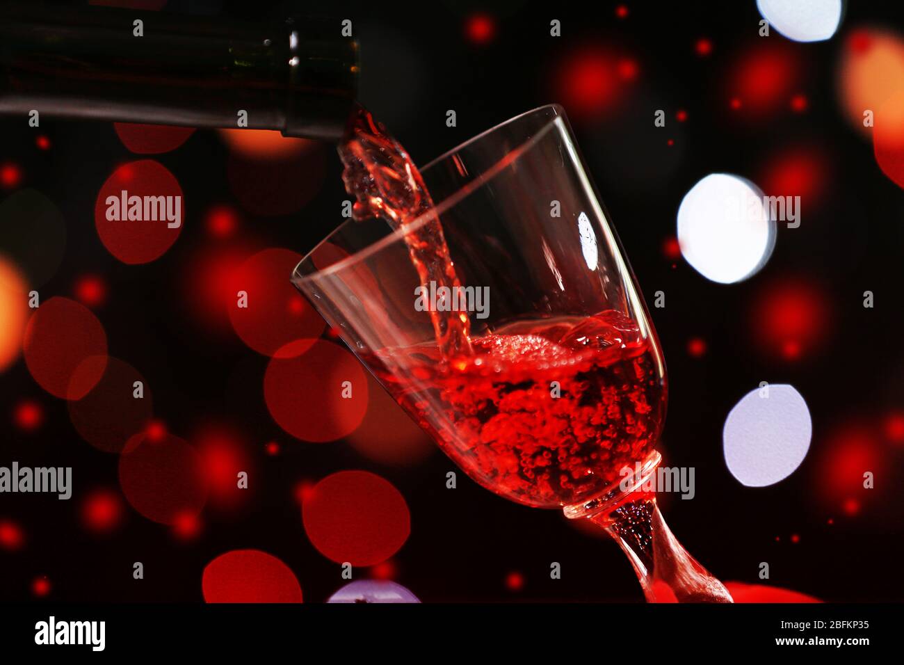 Wine pouring in glass on bright background Stock Photo - Alamy