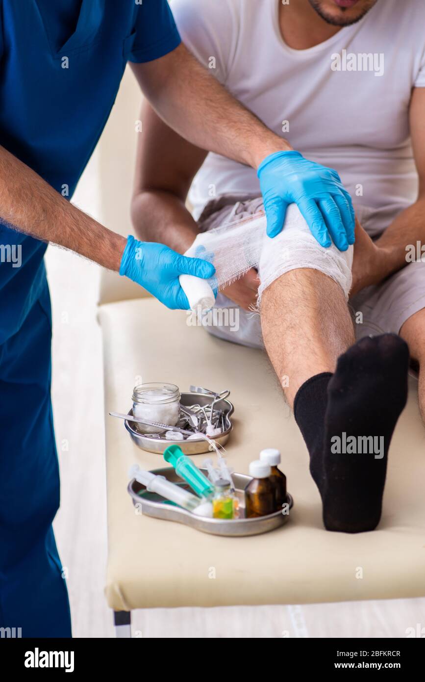 Leg injured man visiting doctor in first aid concept Stock Photo - Alamy