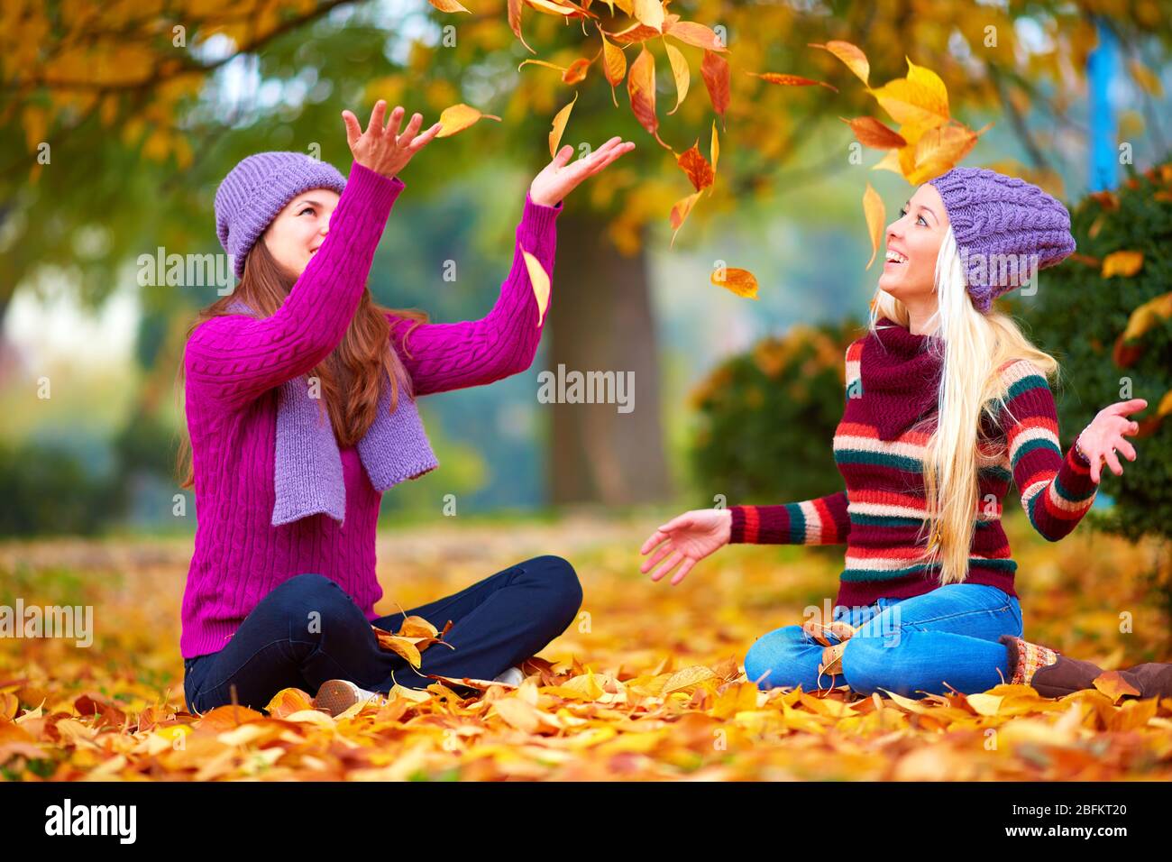 happy friends playing in vibrant autumn park Stock Photo - Alamy