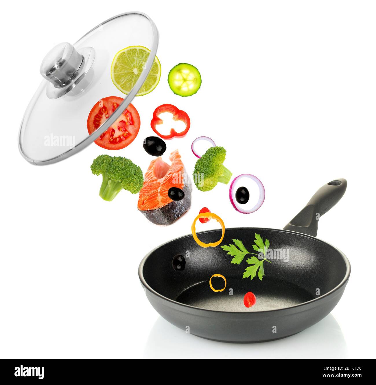 Fresh ingredients falling in the frying pan isolated on white Stock ...