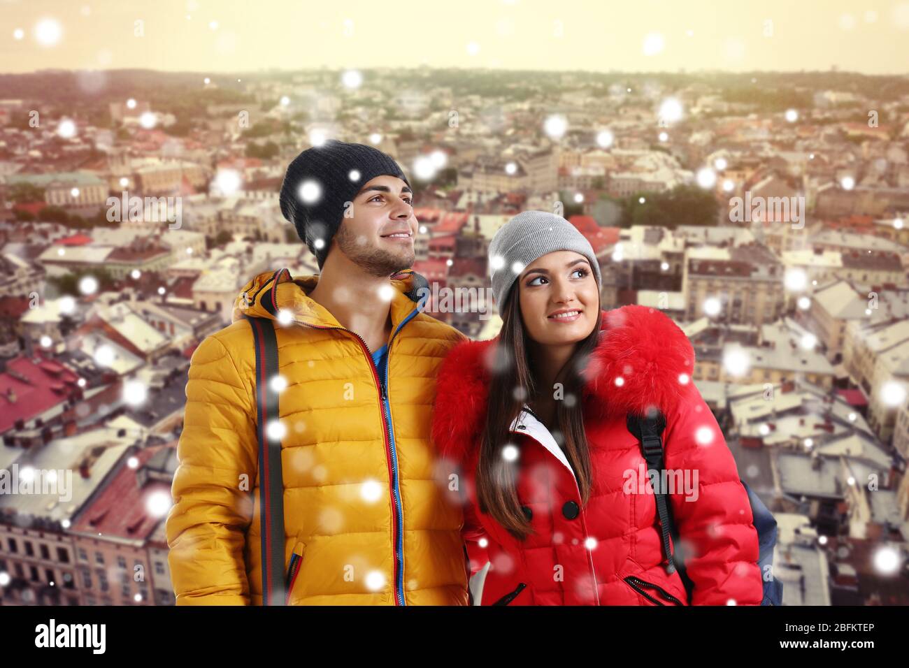 Happy couple on city background over snow effect Stock Photo - Alamy