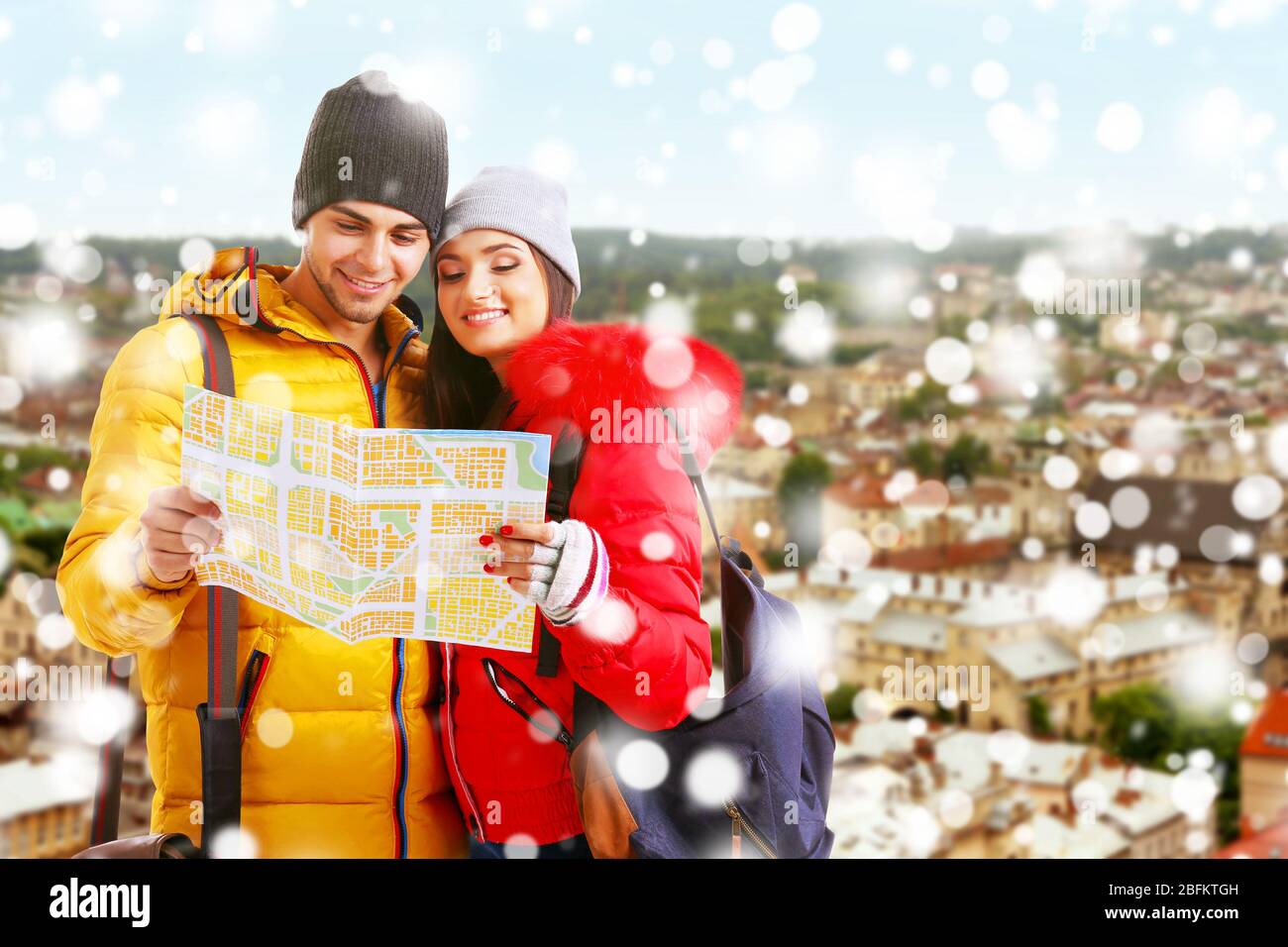 Happy tourists on city background over snow effect Stock Photo - Alamy