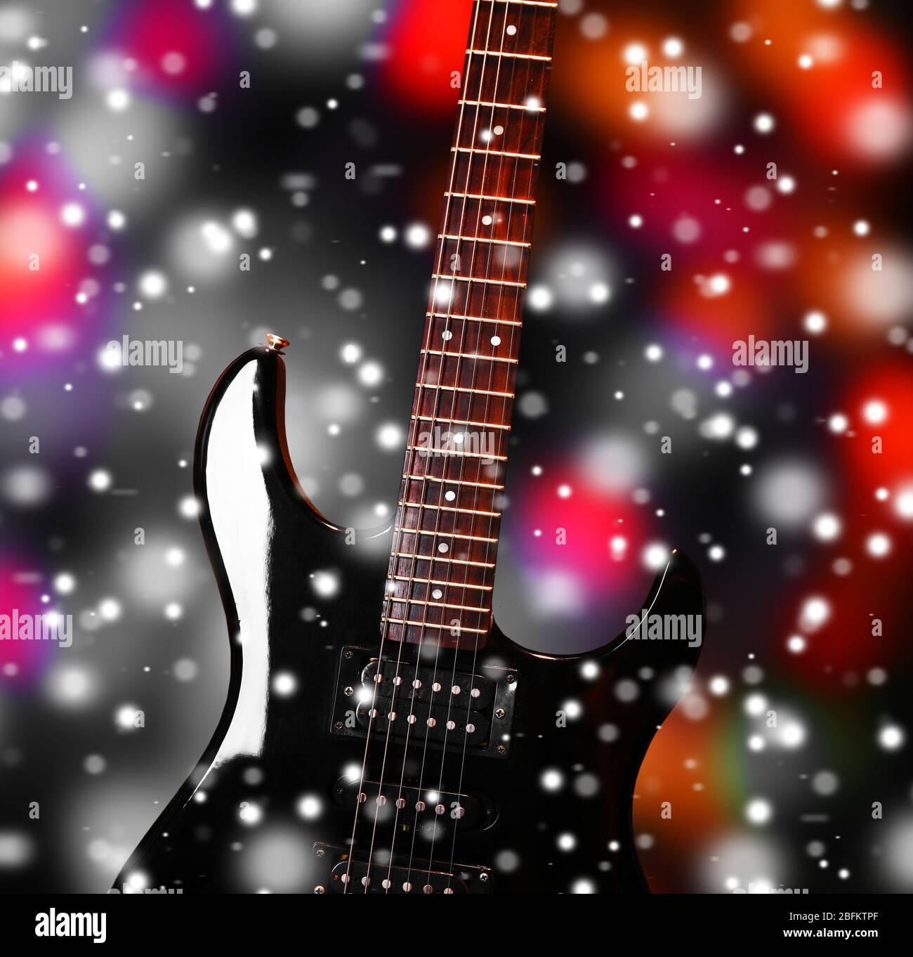 Guitar on bright background over snow effect Stock Photo - Alamy