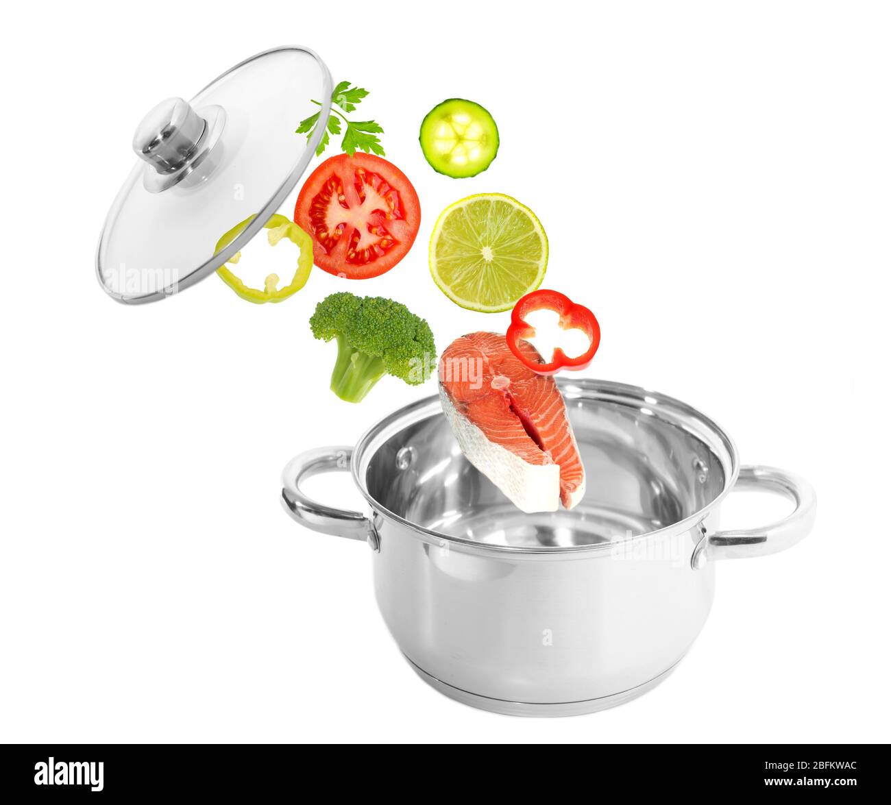 Fresh ingredients falling into a casserole pot isolated on white Stock ...