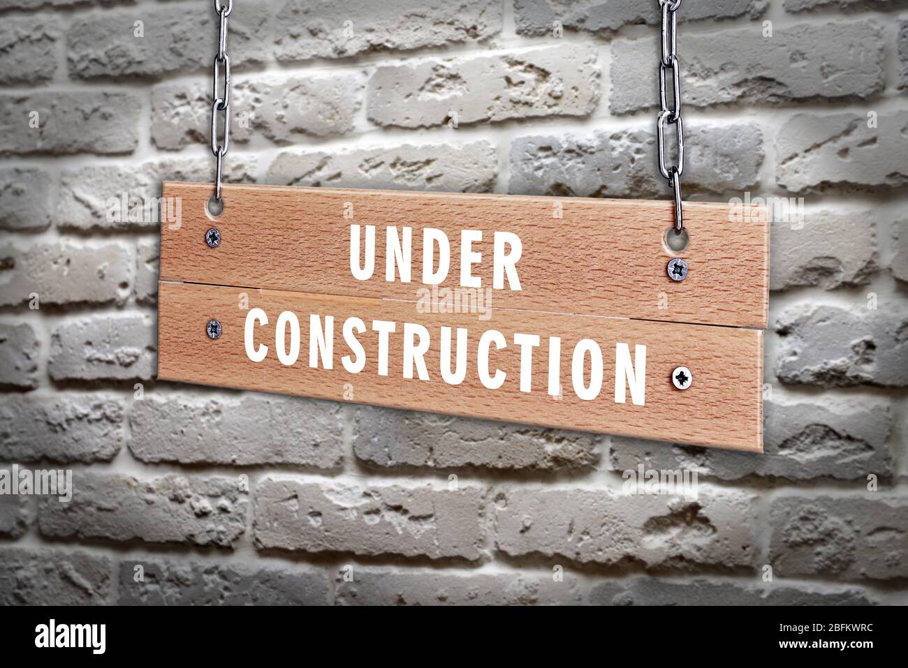 Wooden signboard with text Under Construction on brick wall background ...