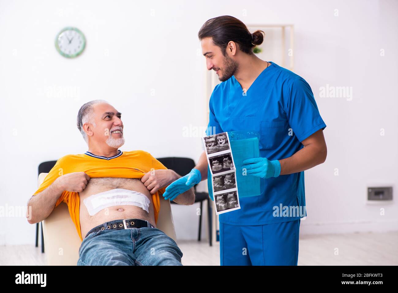 Old man visiting male doctor Stock Photo - Alamy