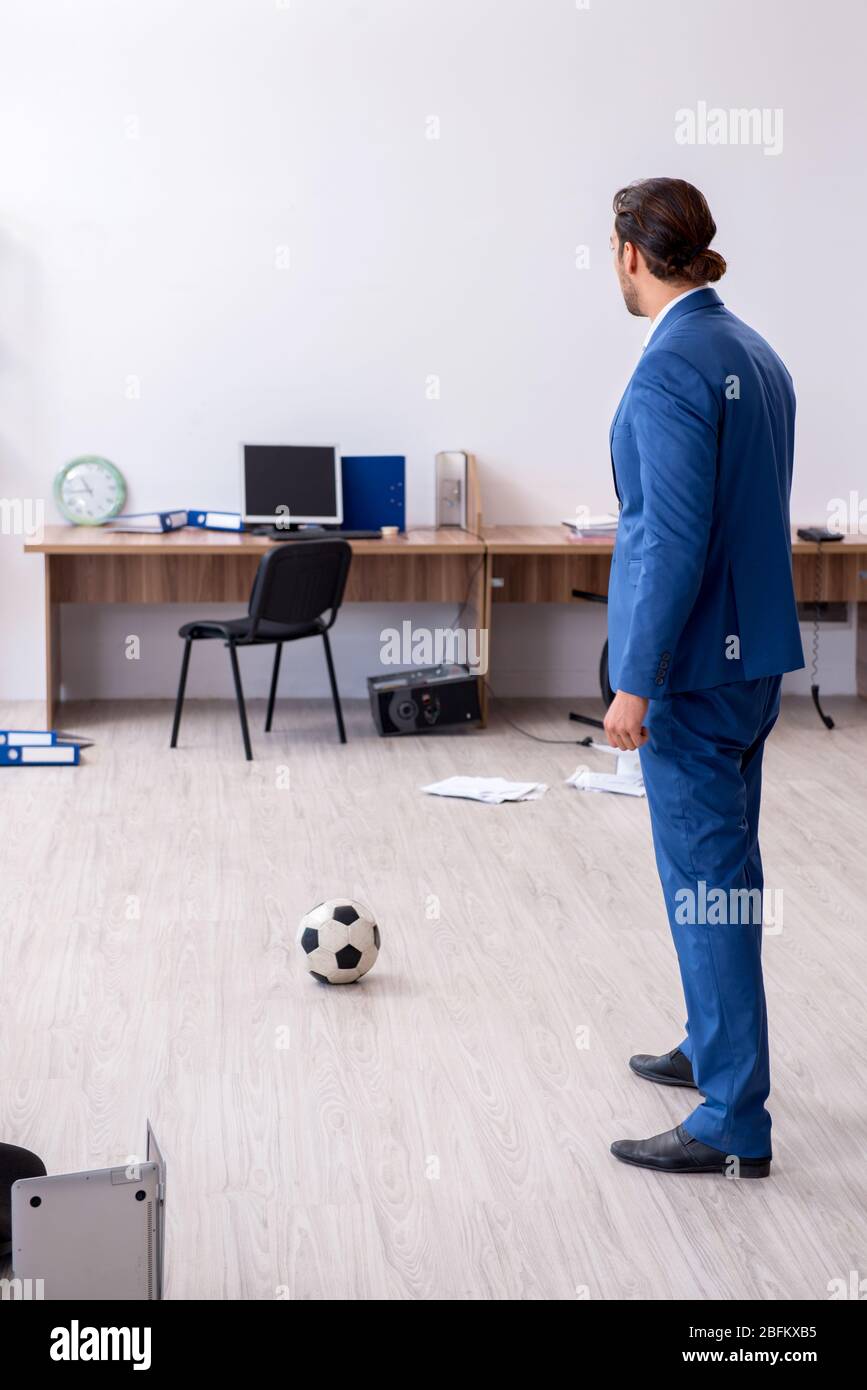 Young employee playing football in the office Stock Photo - Alamy