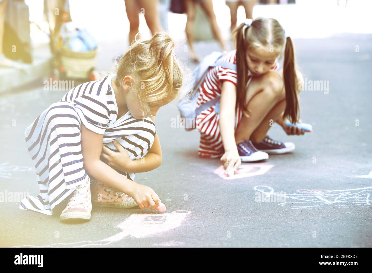 Happy active children drawing with chalk on asphalt Stock Photo - Alamy