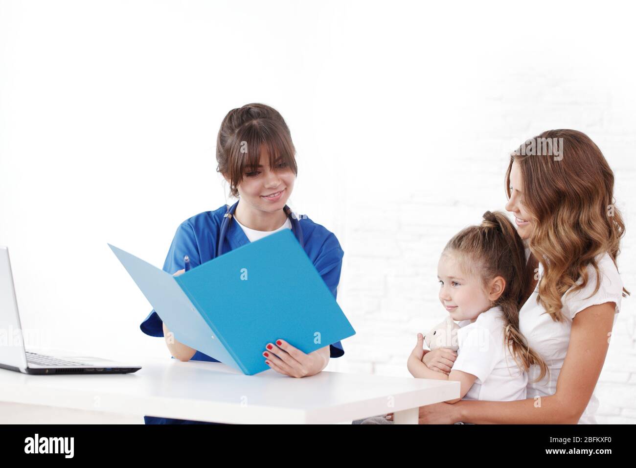 Pediatrician doctor writing prescription to girl and her mother Stock ...