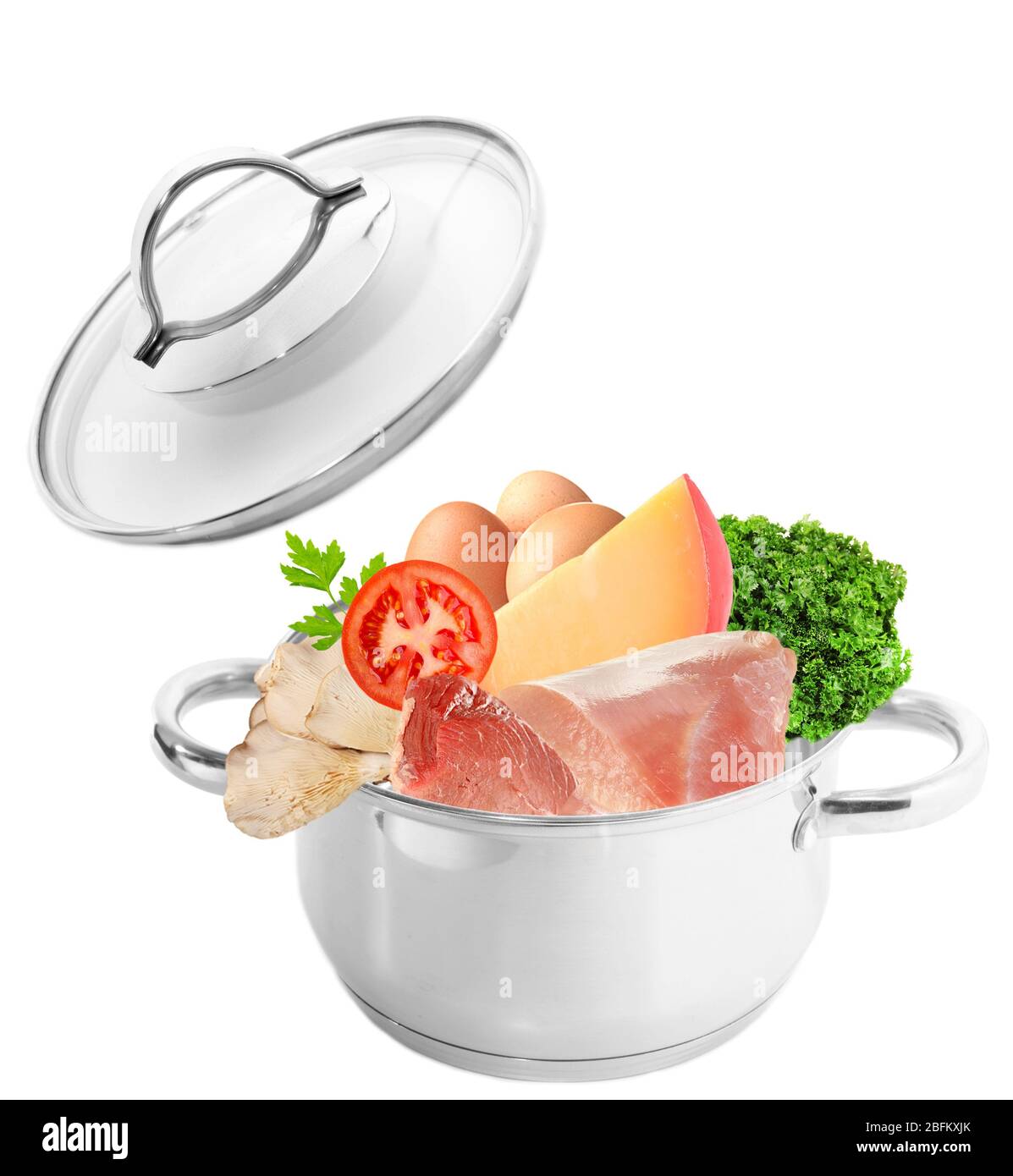 Fresh vegetables falling into a casserole pot isolated on white Stock ...