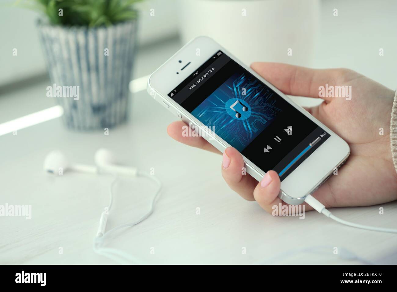 Music smartphone in female hand, on light background Stock Photo - Alamy