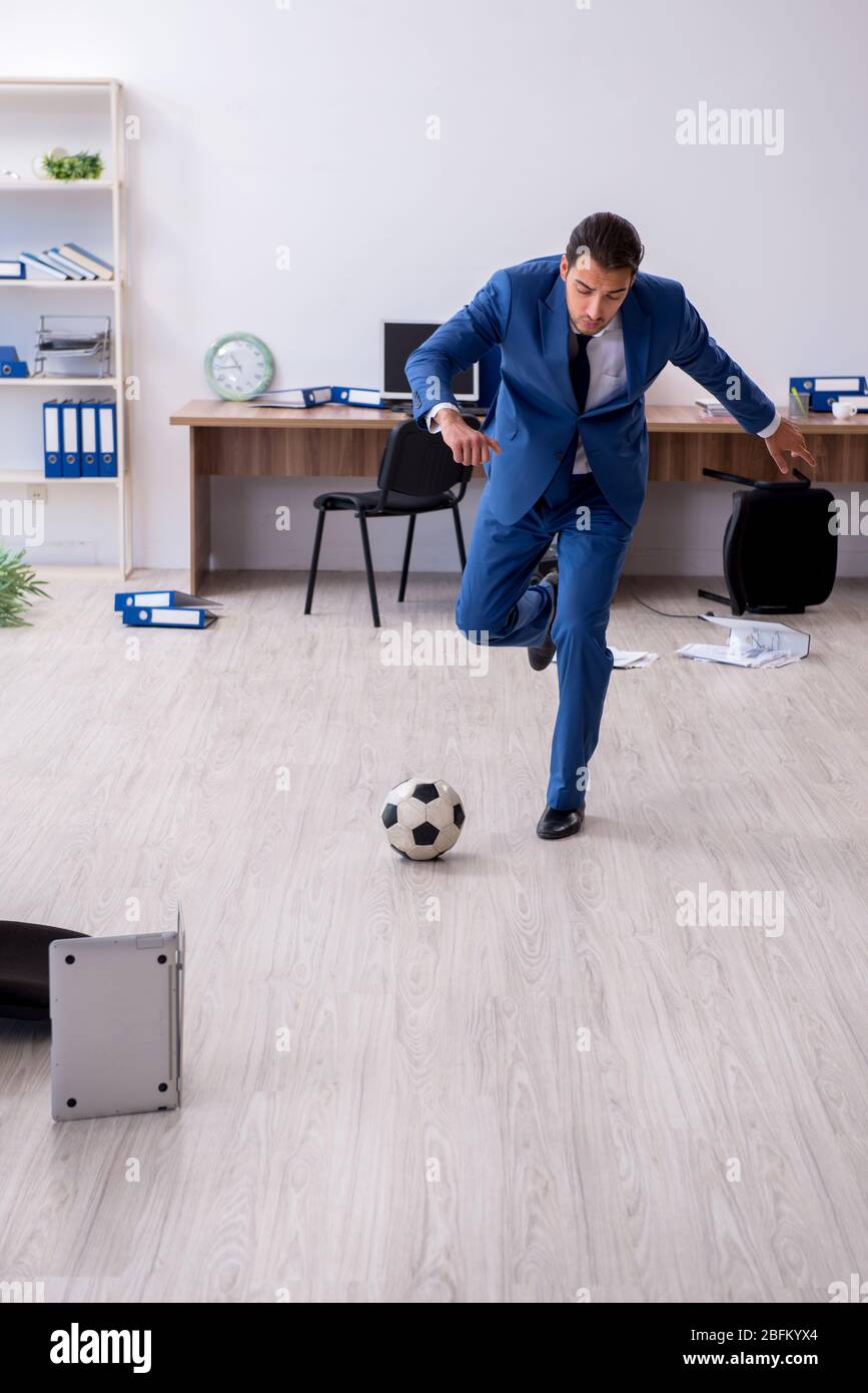 Young employee playing football in the office Stock Photo - Alamy