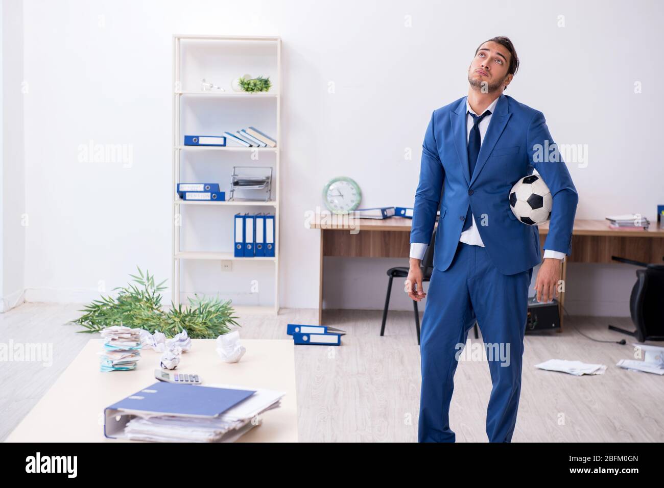 Young employee playing football in the office Stock Photo - Alamy