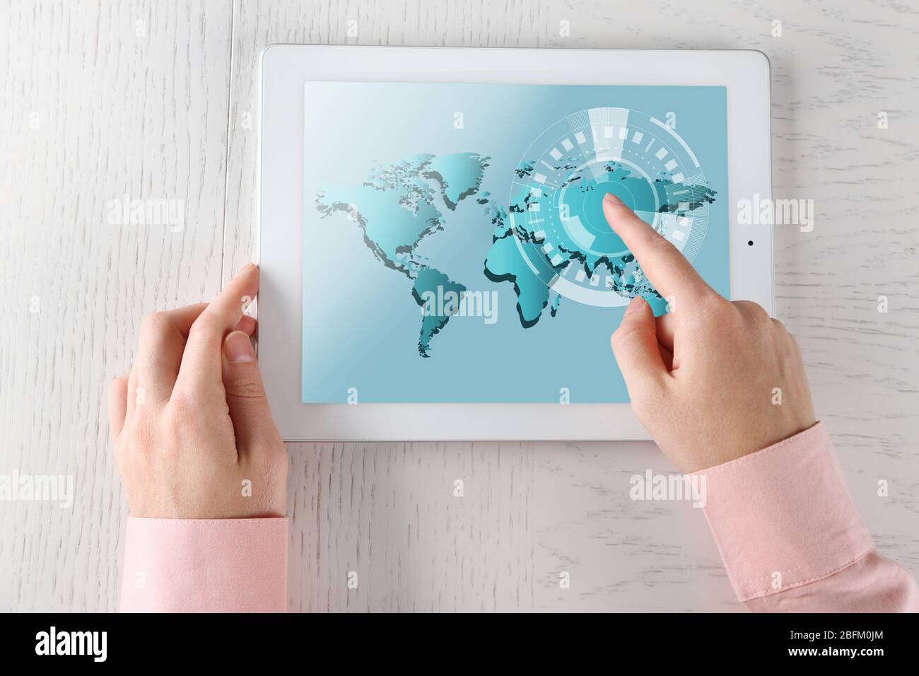 Close up of human hand touching screen of tablet pc with world map and ...