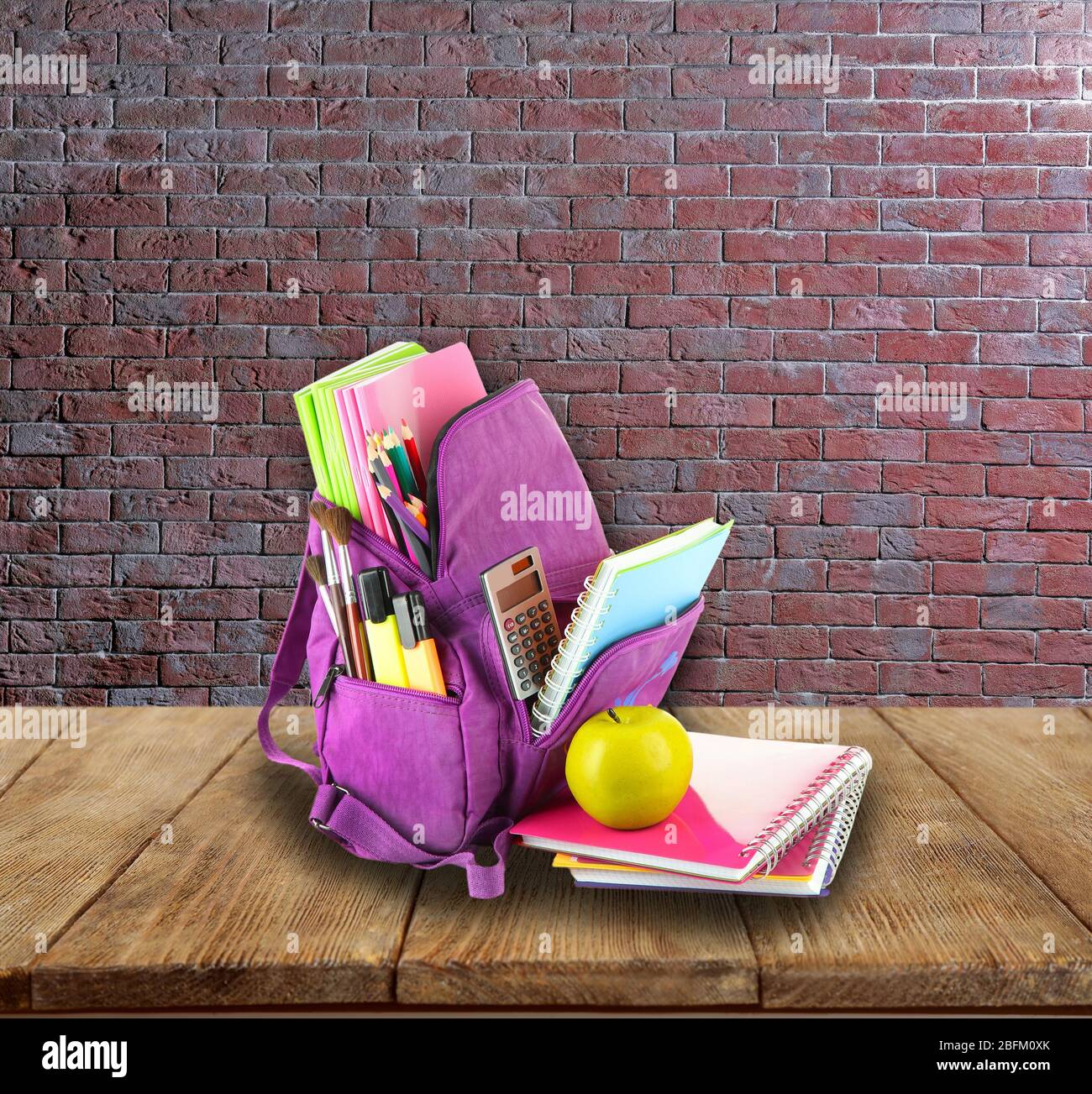 School backpack on wooden desk, on bricks wall background Stock Photo ...
