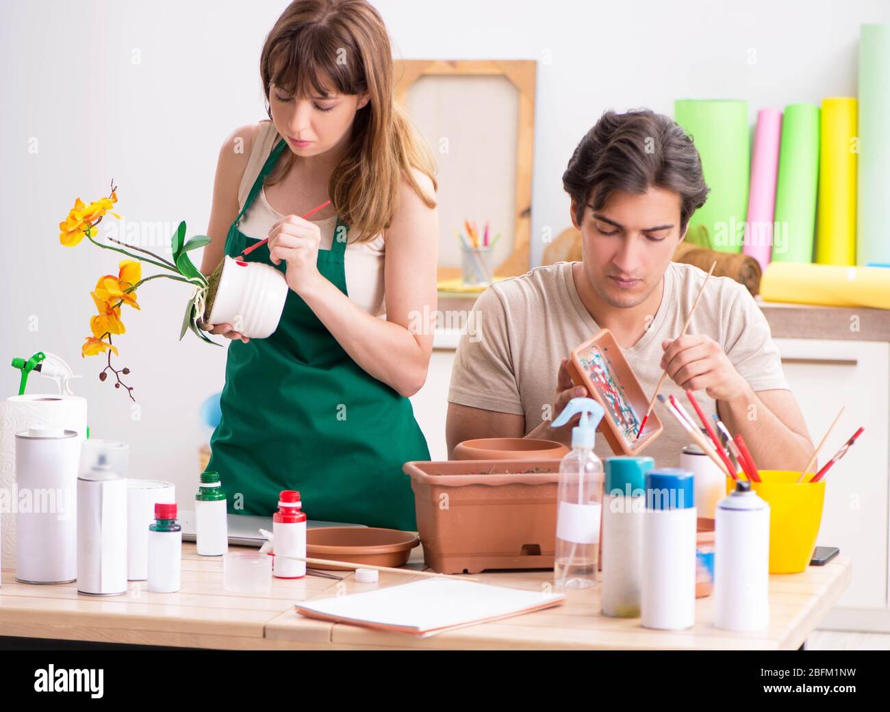 The couple decorating pots in workshop during class Stock Photo - Alamy
