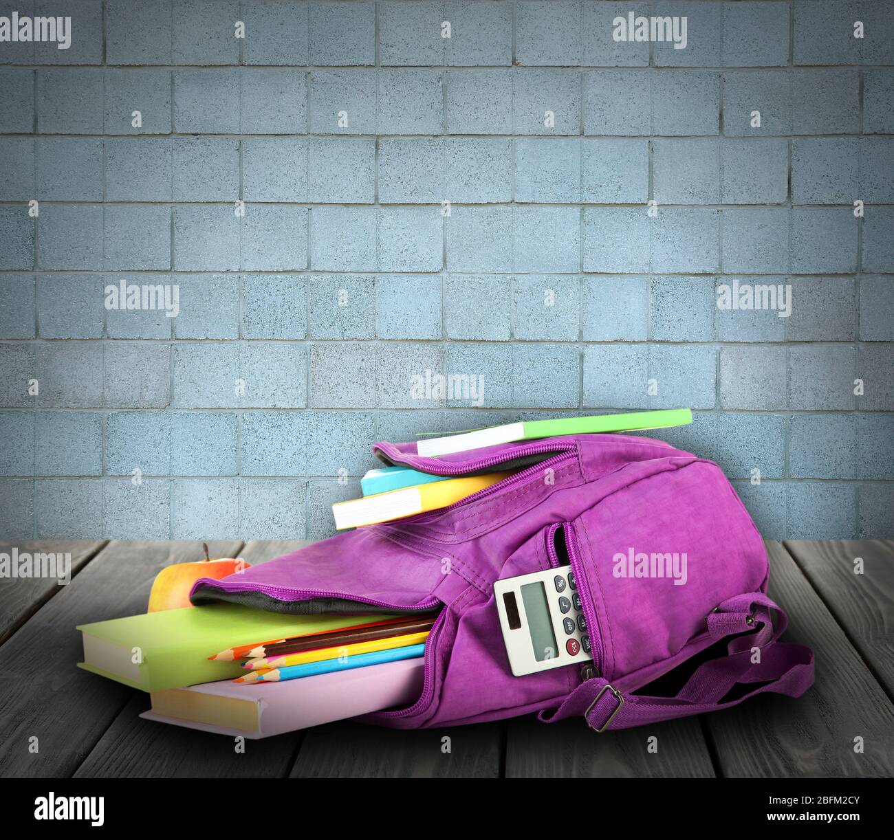 School backpack on wooden desk, on bricks wall background Stock Photo ...