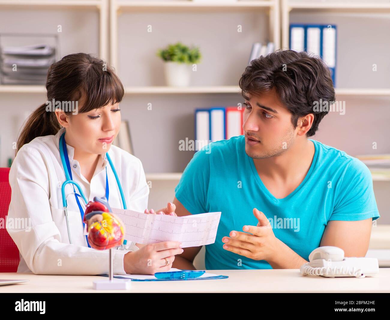 The young man visiting female doctor cardiologist Stock Photo - Alamy